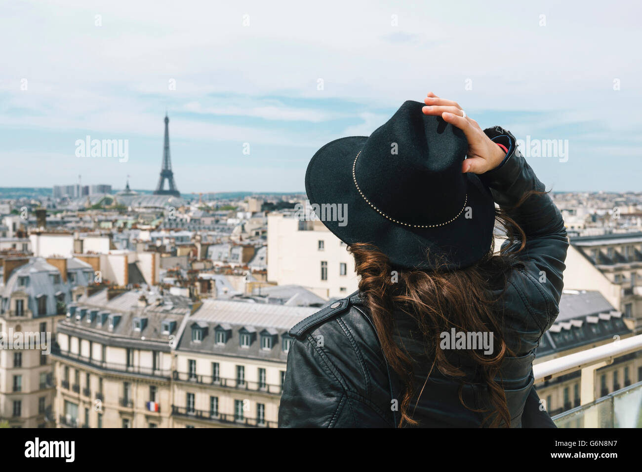 France, Paris, back view of woman at viewpoint wearing a black hat ...
