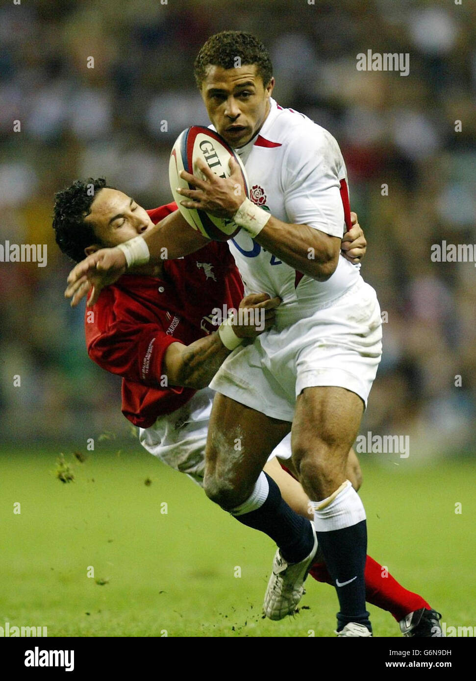 England's Jason Robinson tries to escape the tackle of NZ Barbarian ...