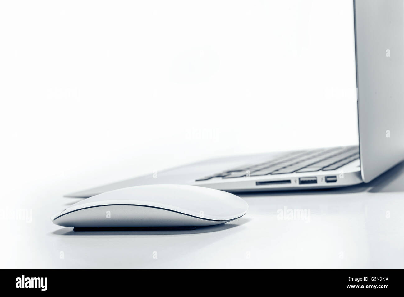 Laptop computer on white table with mouse. Filters added Stock Photo ...