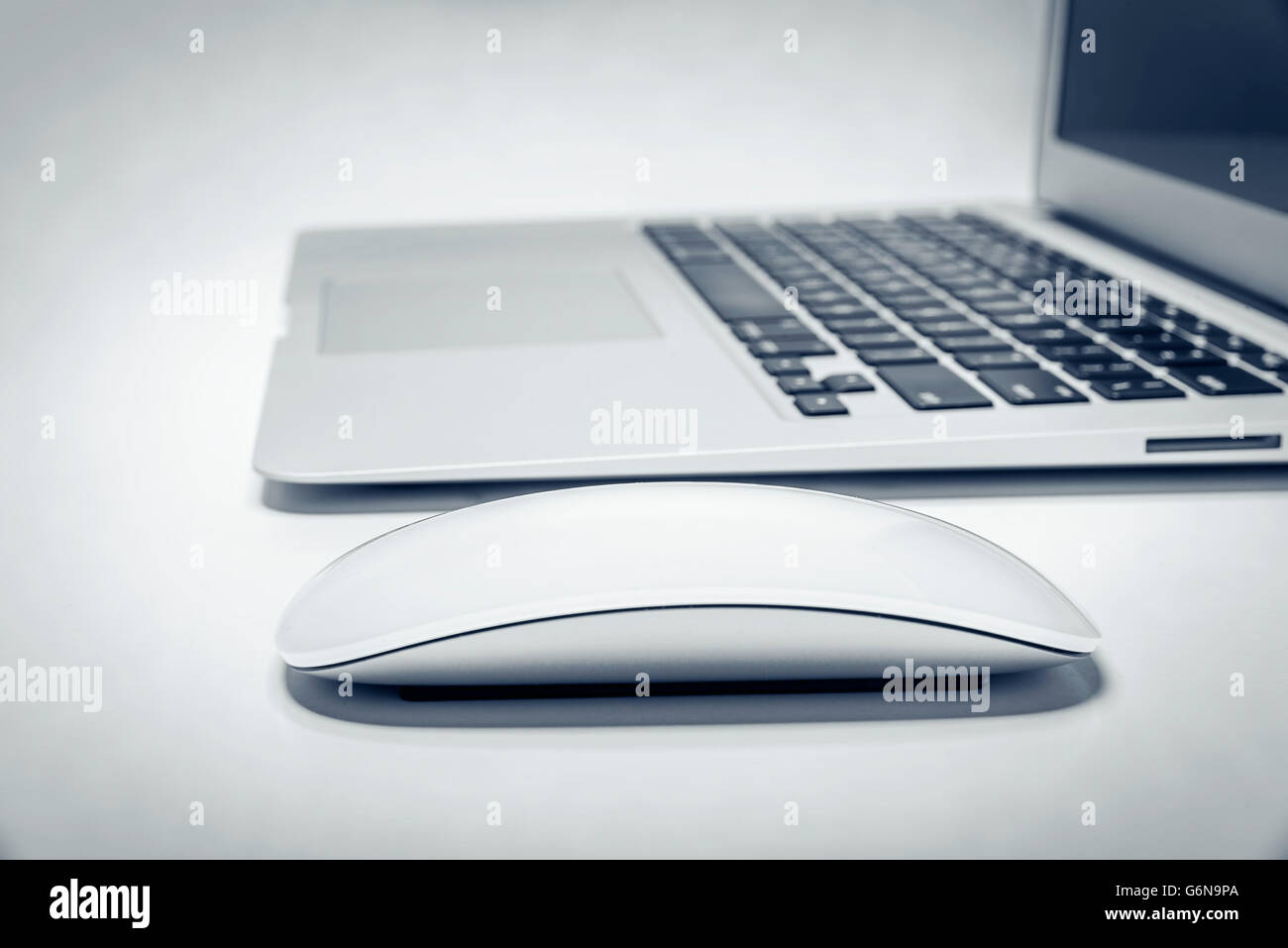 Laptop computer on white table with mouse. Filters added Stock Photo ...