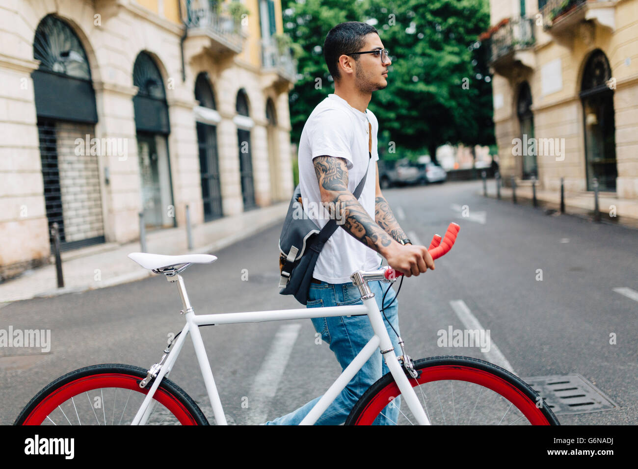 Young man walking with a bicycle in the city Stock Photo - Alamy