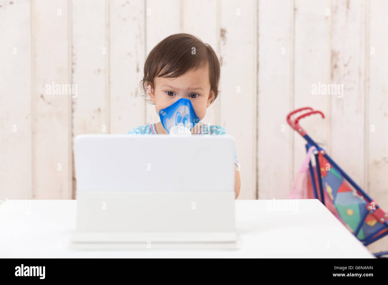 Girl using inhaler looking at digital tablet Stock Photo - Alamy