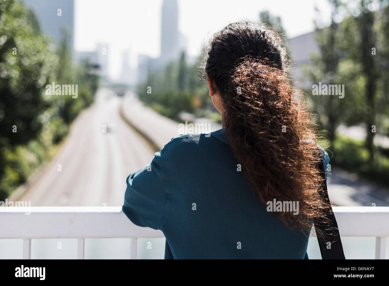Young woman on bridge looking on street Stock Photo - Alamy