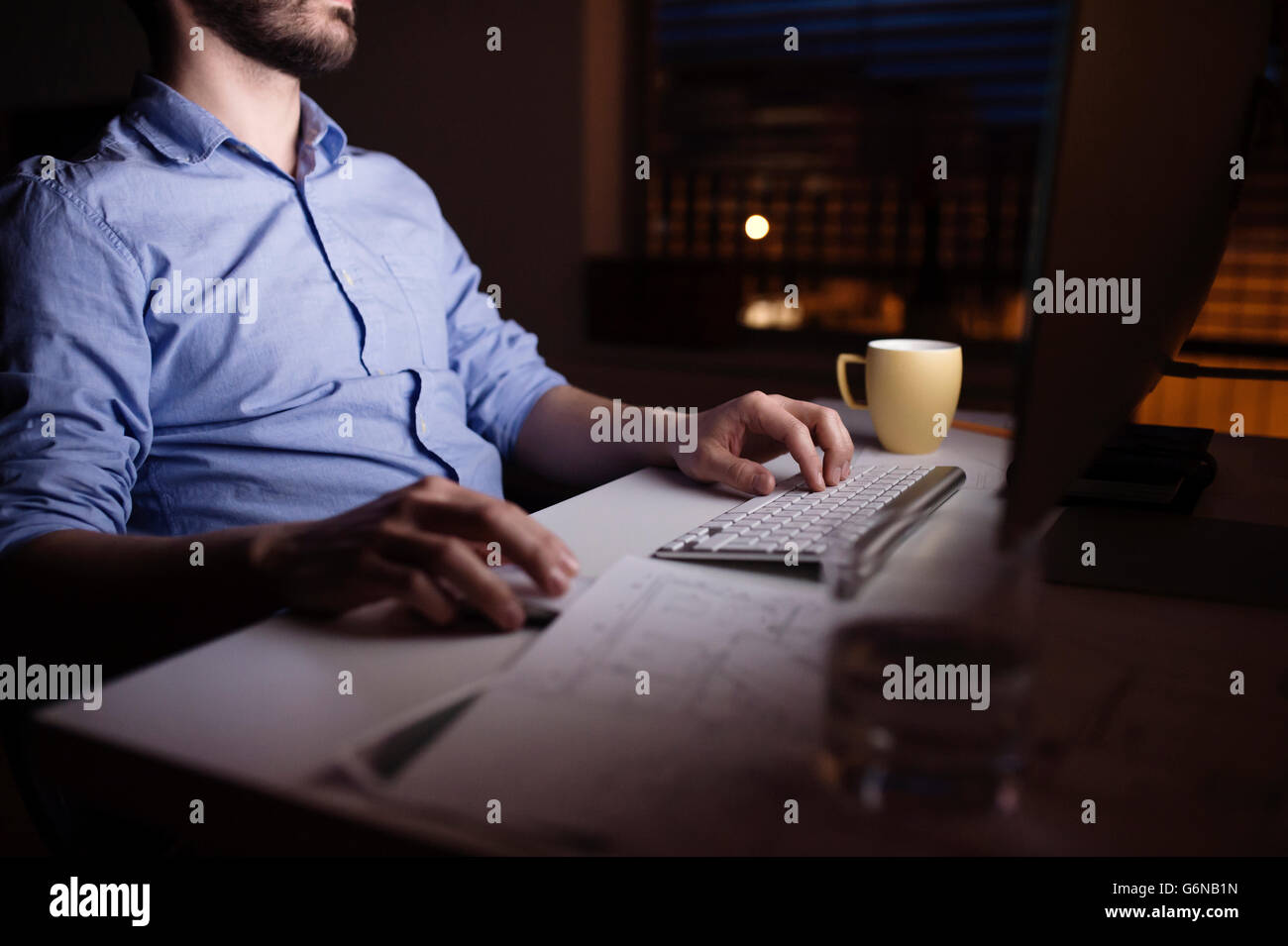 Man working at night, using computer Stock Photo - Alamy