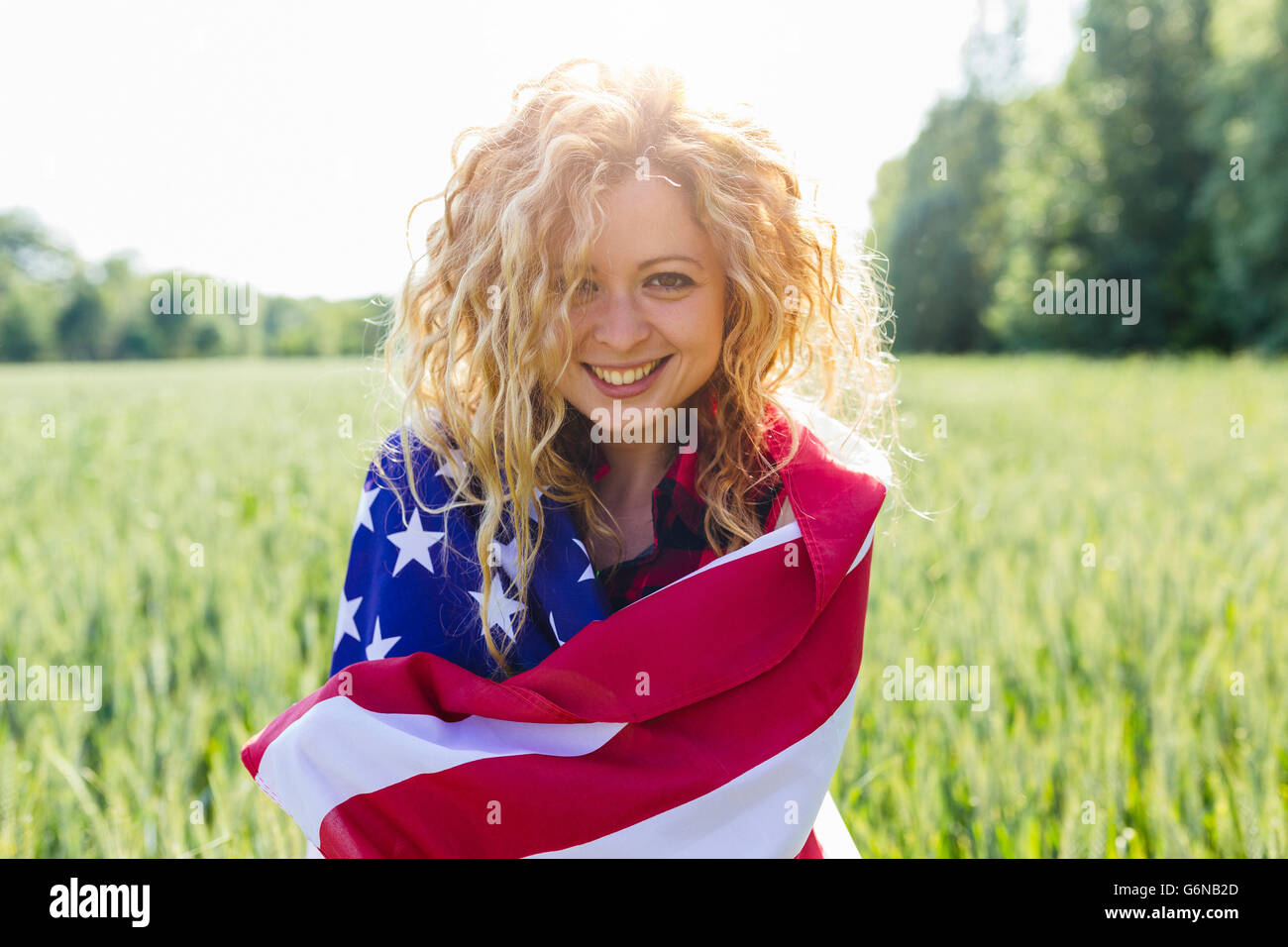 Portrait of smiling woman with American Flag in nature Stock Photo - Alamy