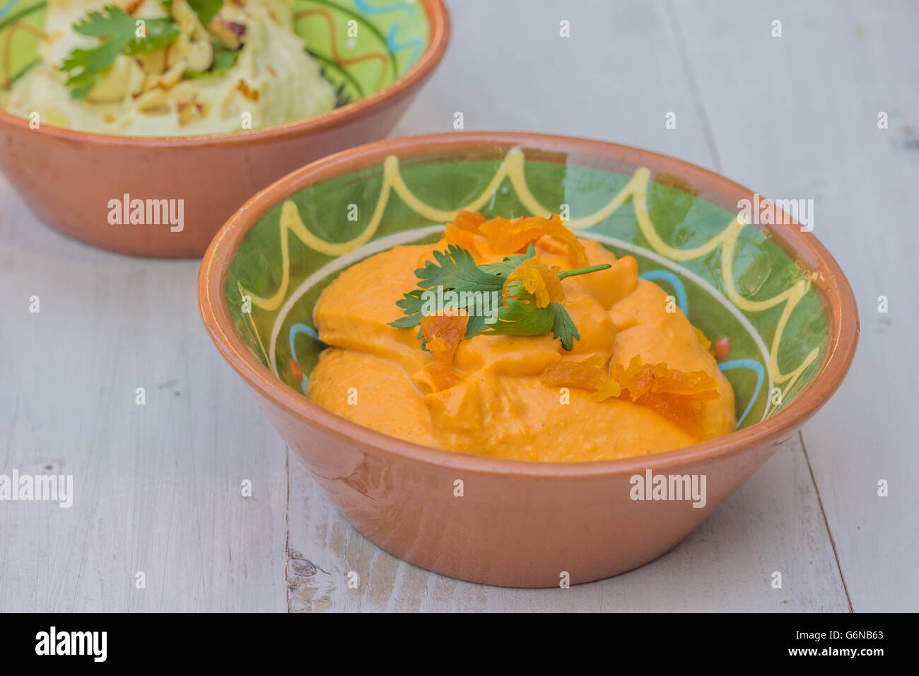 Orange humus on a white wooden table Stock Photo - Alamy