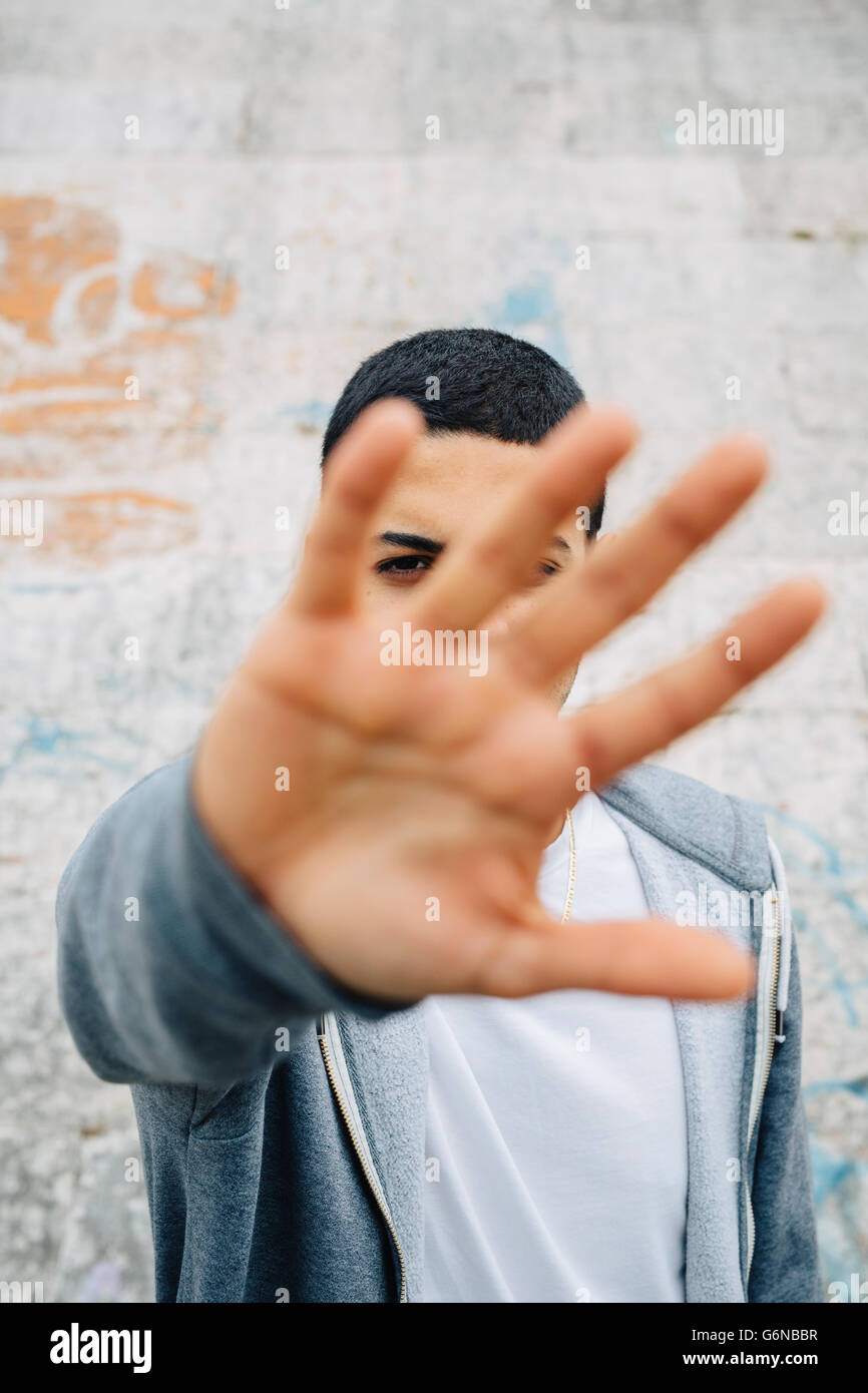 Young man raising his hand Stock Photo - Alamy