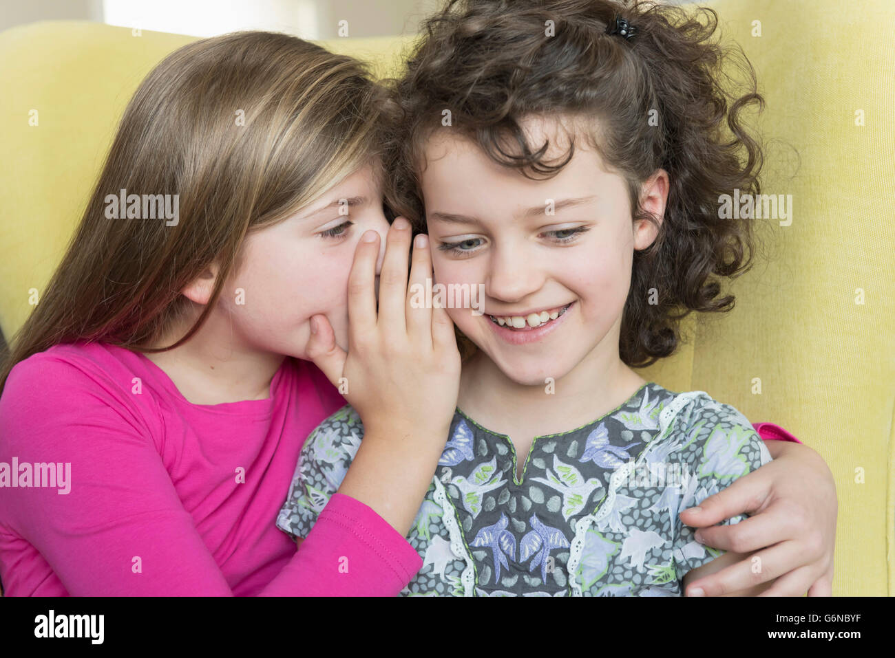 Two girls whispering Stock Photo - Alamy