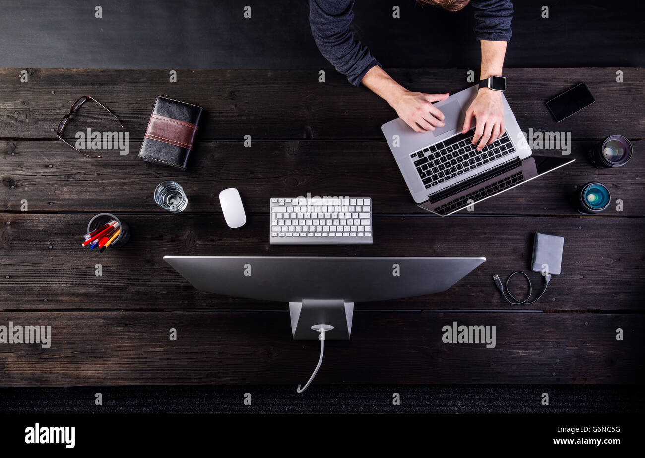 Man working at desk with computer and various digital gadgets Stock ...