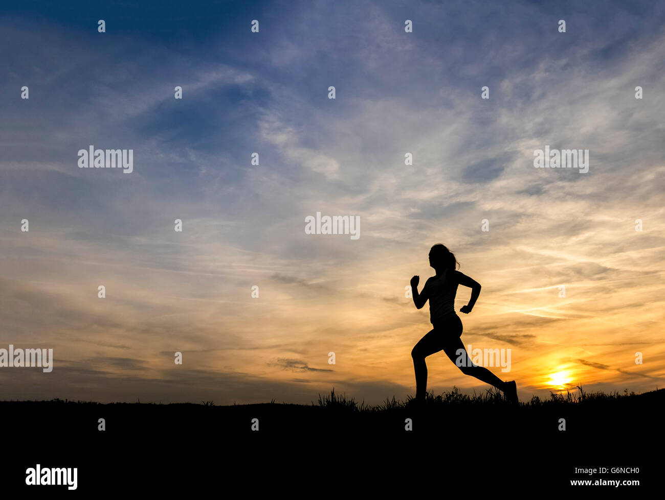 Silhouette of female jogger at sunset Stock Photo - Alamy