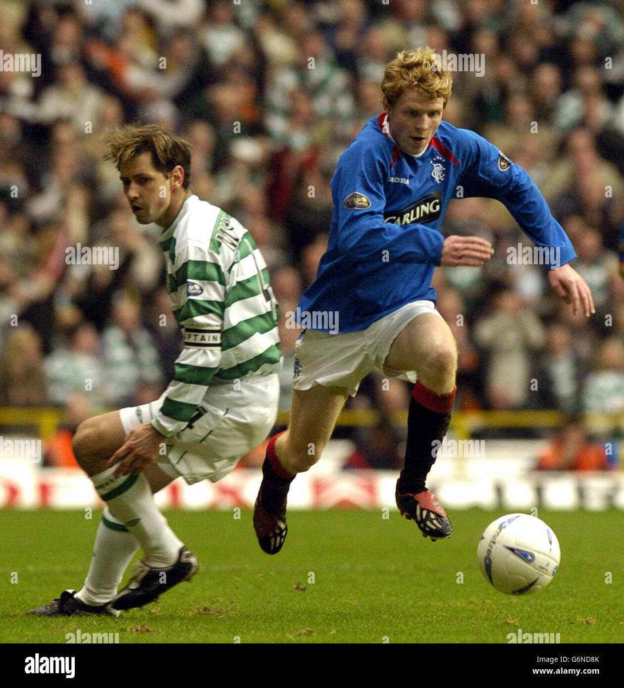 Rangers' Chris Burke (right) skips past Celtic's Jackie McNamara during ...