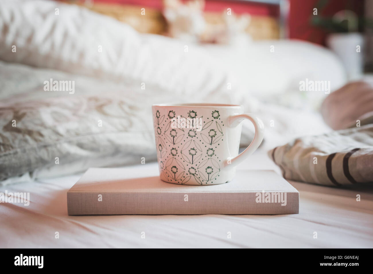 Book and cup of coffee on a bed Stock Photo - Alamy