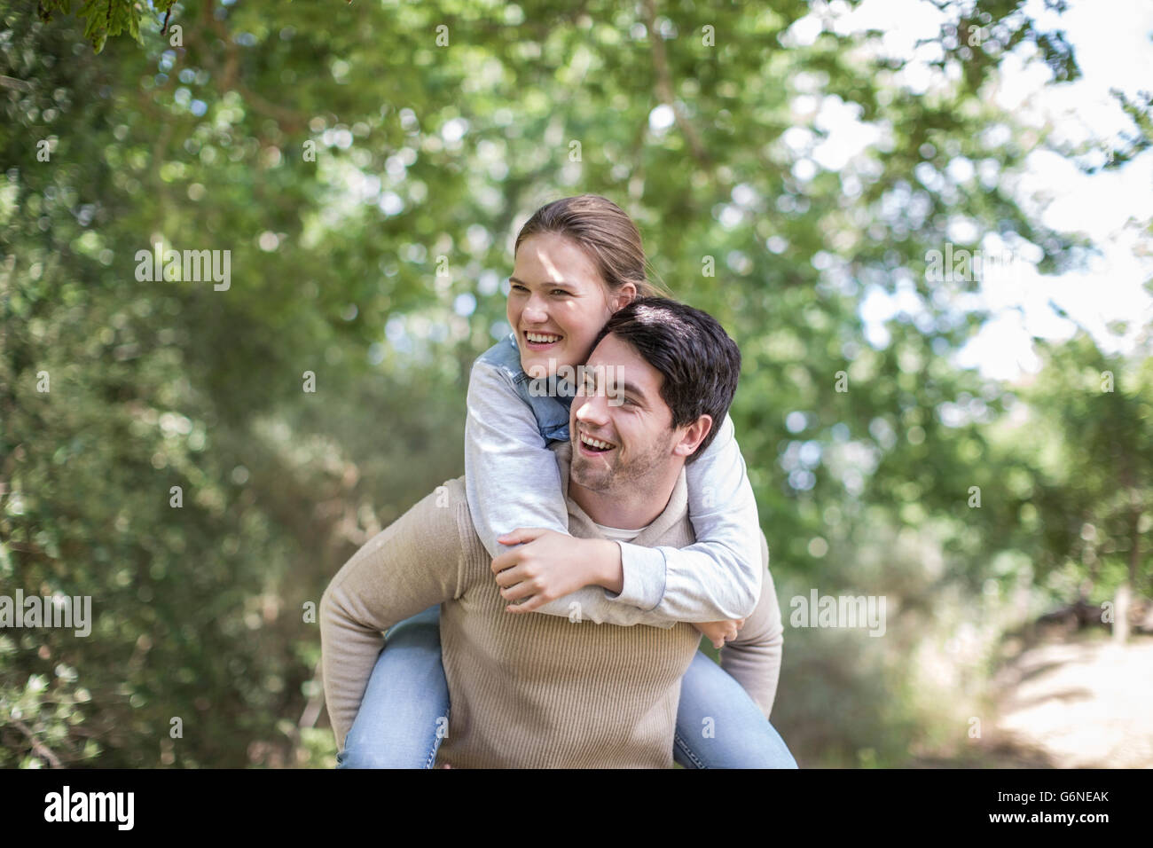 Young man carrying his girfriend piggyback in the nature Stock Photo ...