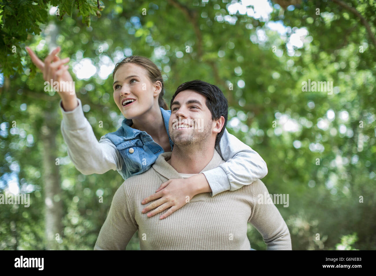 Young man carrying his girfriend piggyback in the nature Stock Photo ...