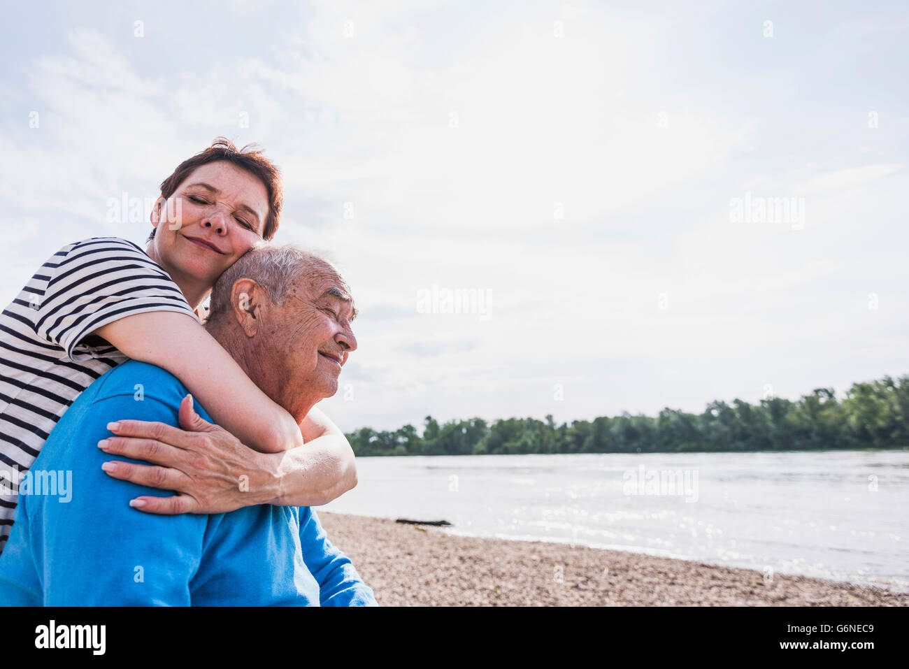 Adult daughter hugging her father at riverside Stock Photo - Alamy
