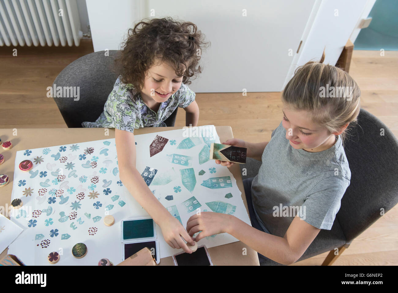 Two girls stamping on paper Stock Photo - Alamy