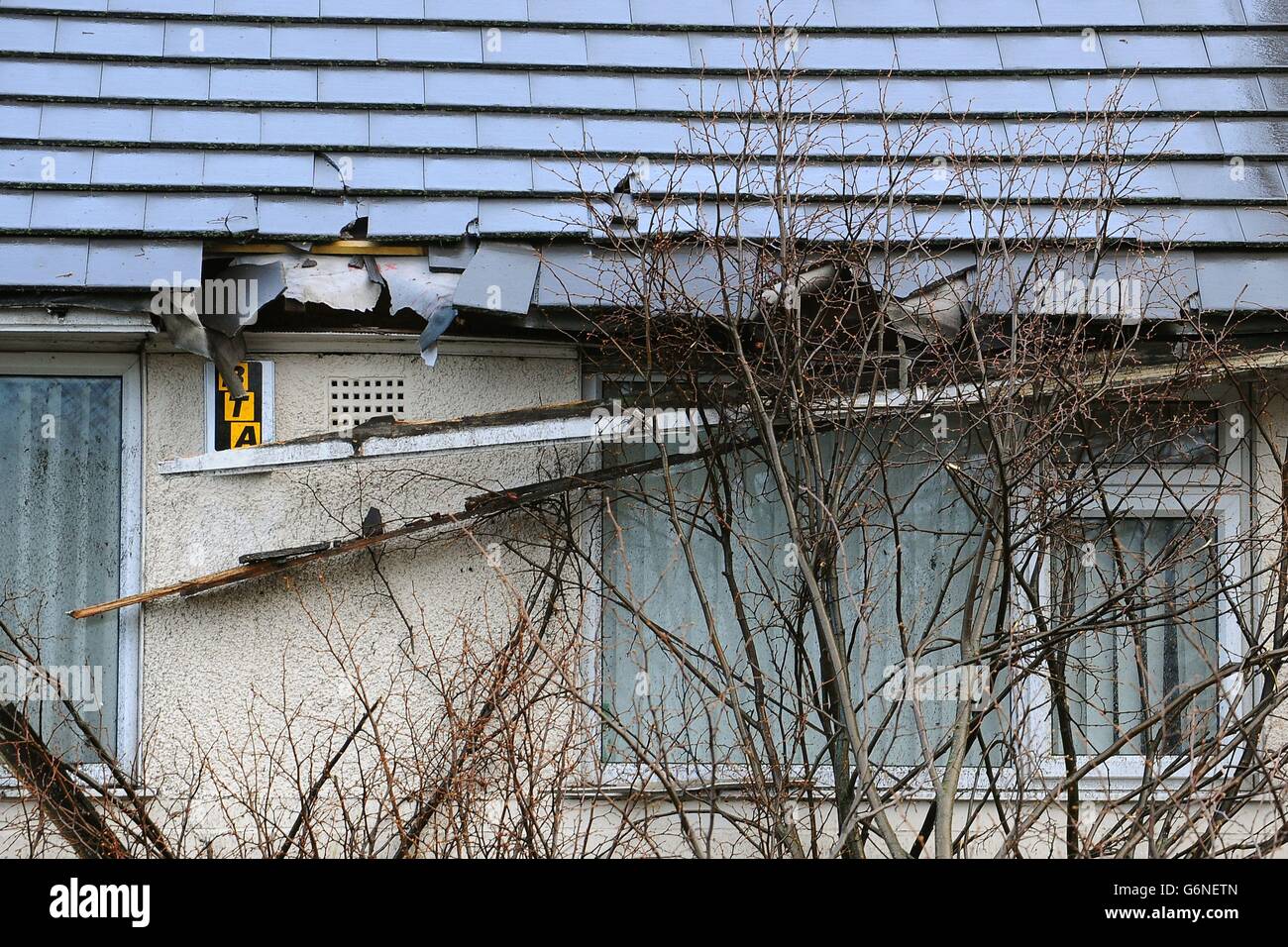 Damage to the roof of a house after being hit by a falling tree on ...