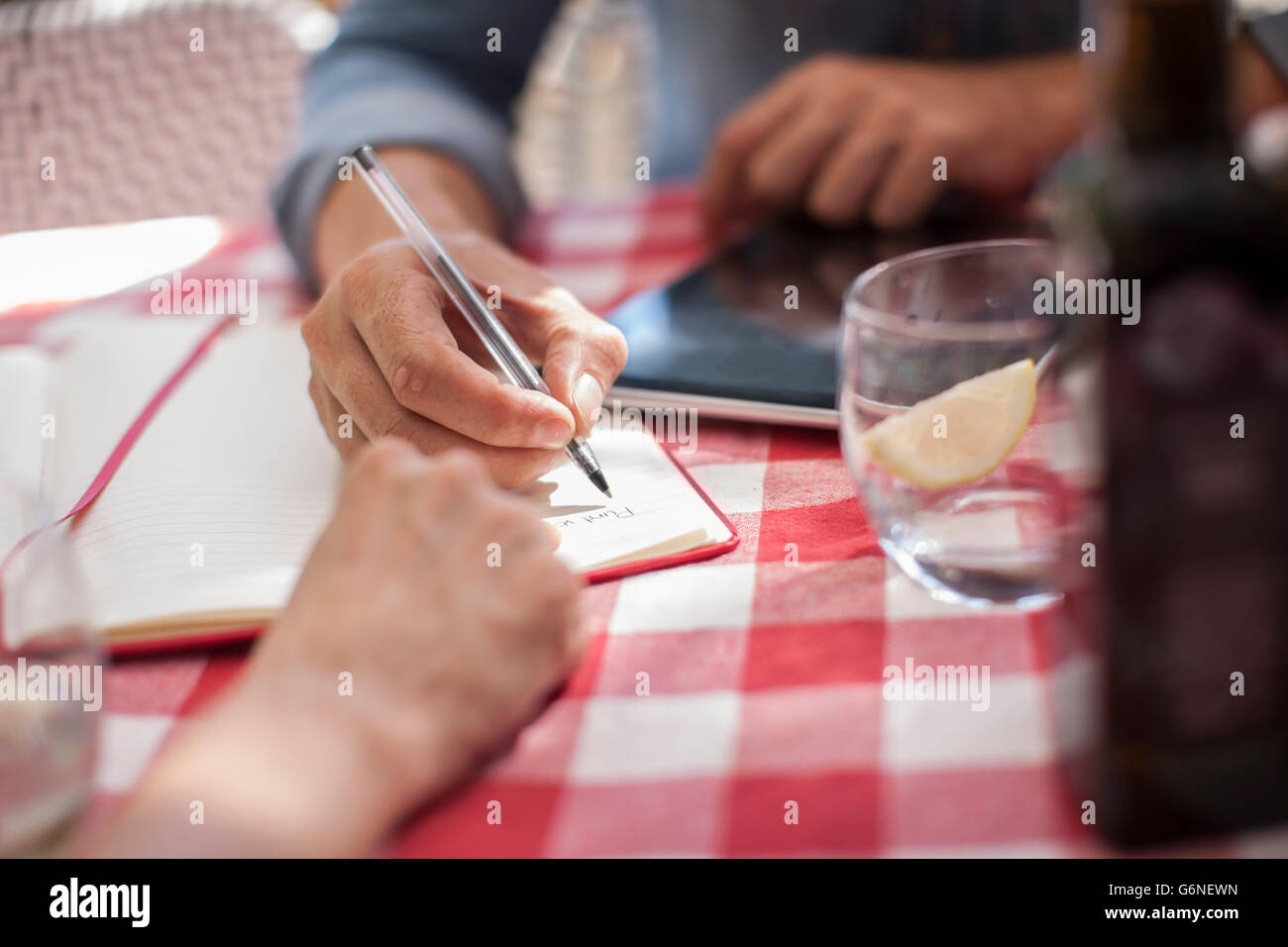 Person making notes in red note book Stock Photo - Alamy