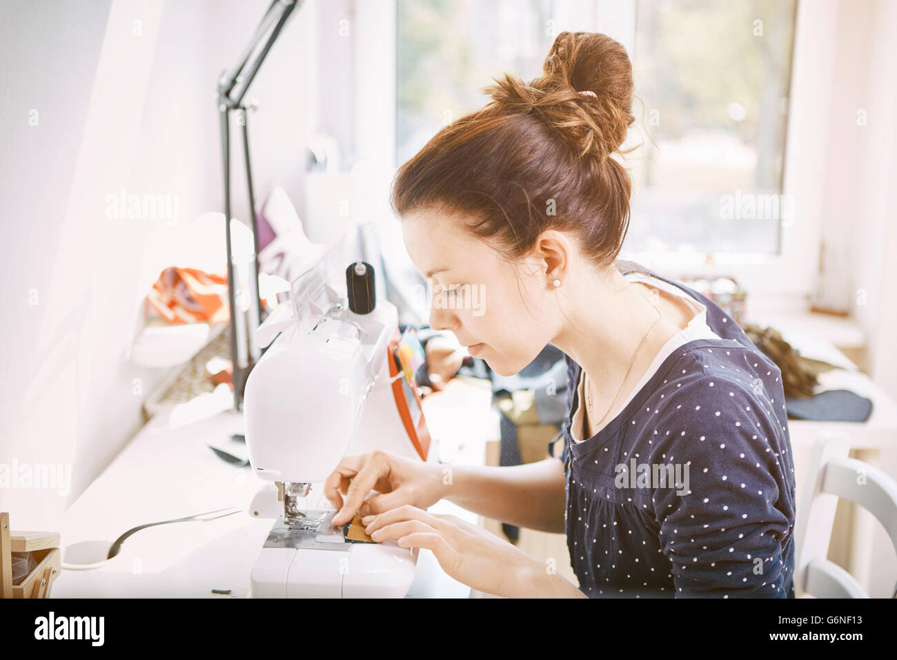 Young woman working on sewing machine Stock Photo - Alamy
