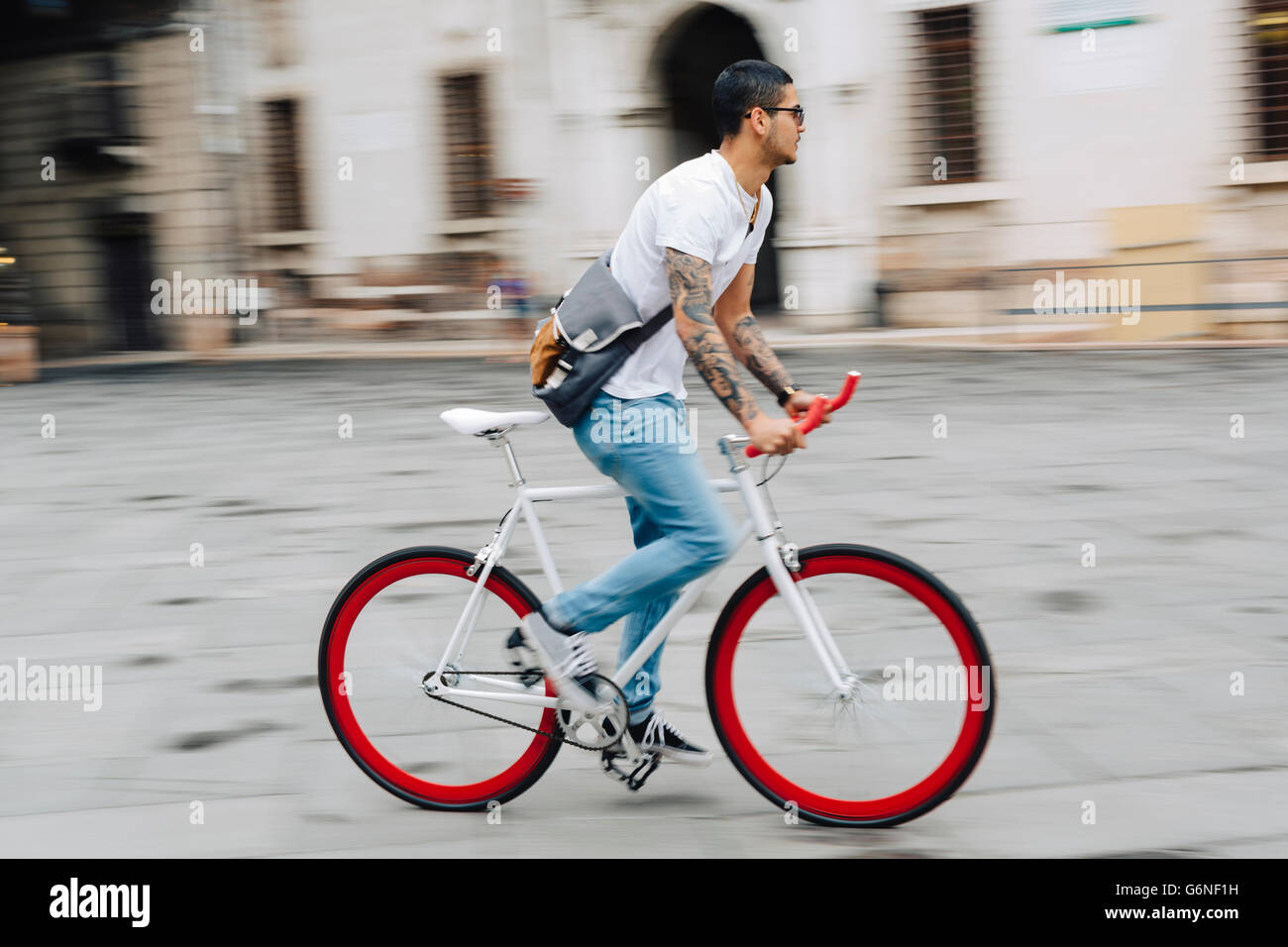 Young man riding bicycle in the city Stock Photo - Alamy