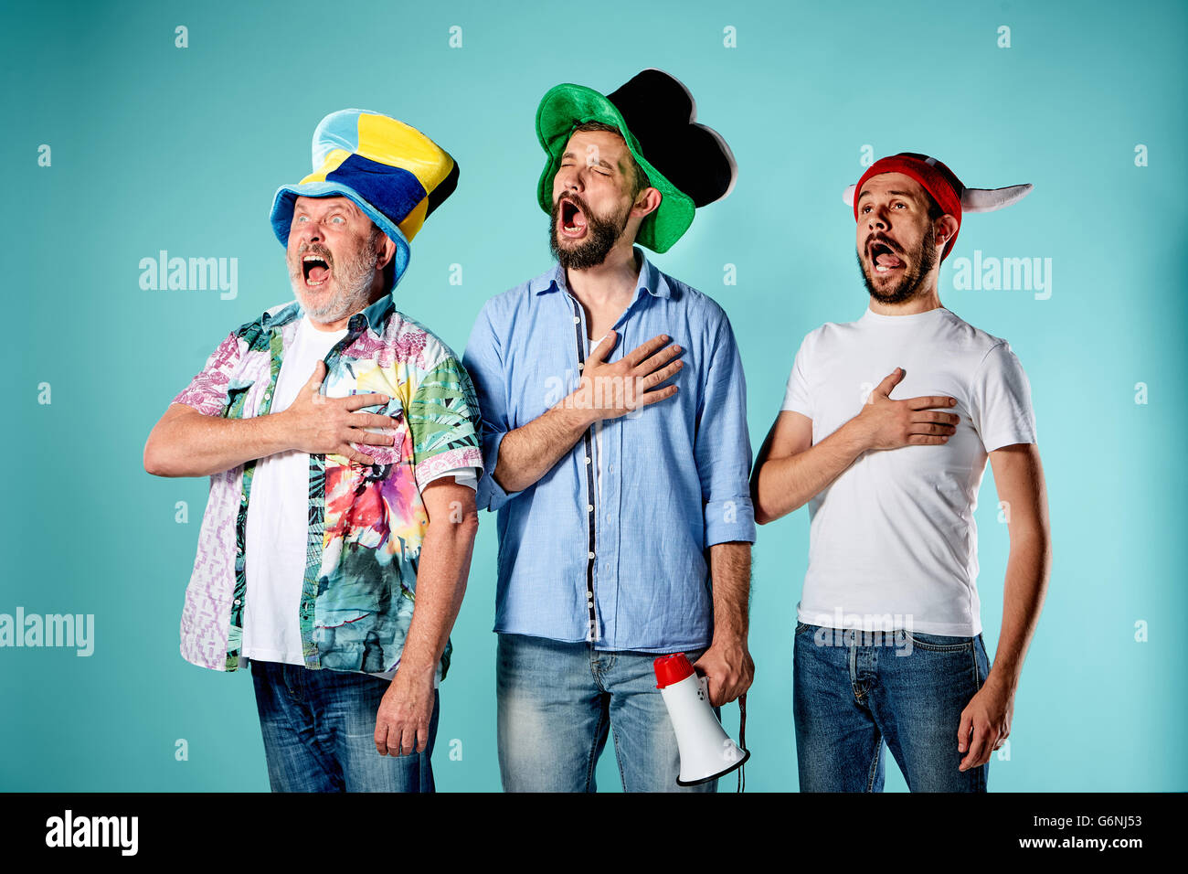 The three football fans singing the national anthem over blue Stock ...