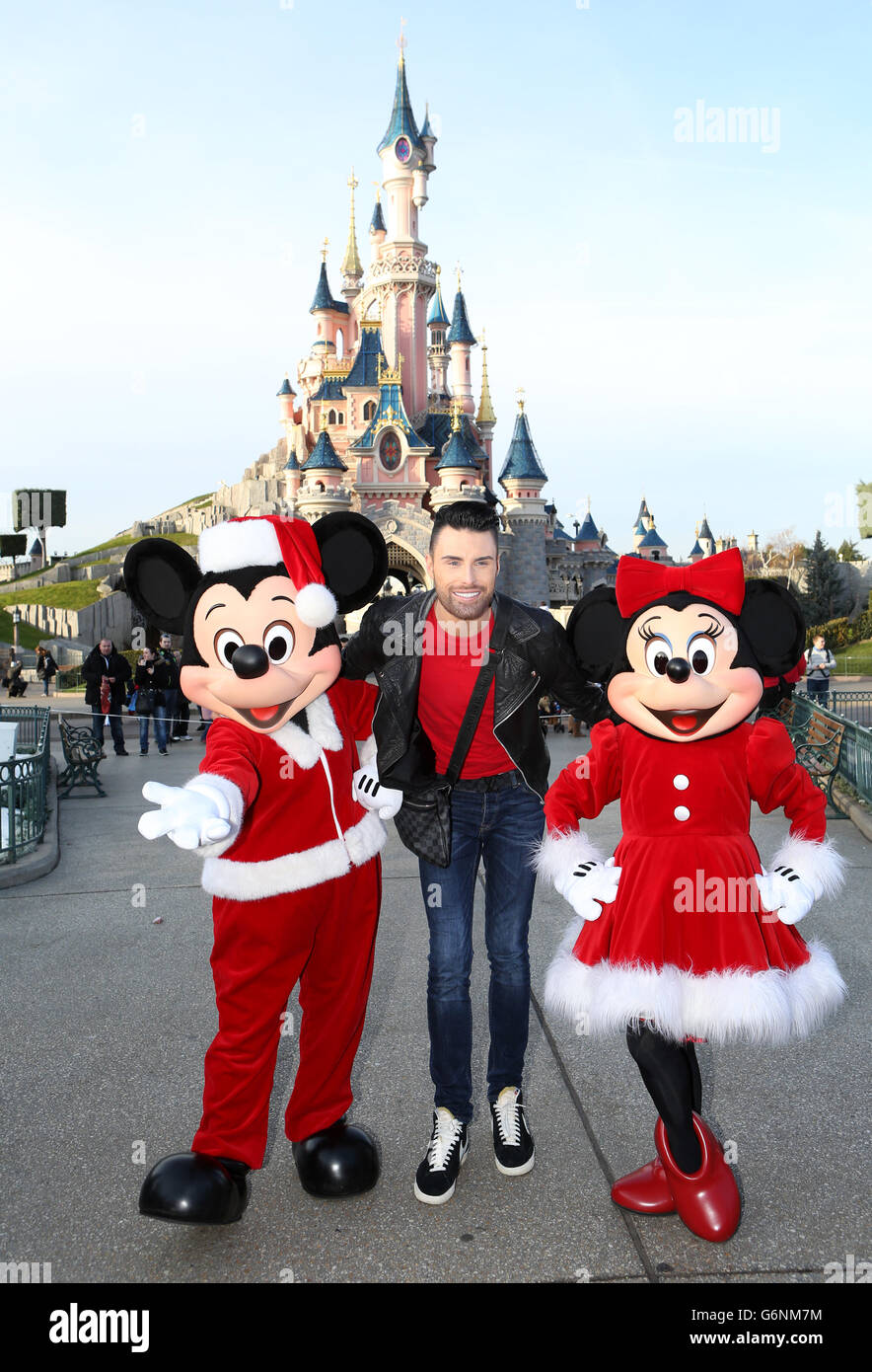 Rylan Clark poses with Minnie and Mickey Mouse in front of the castle ...