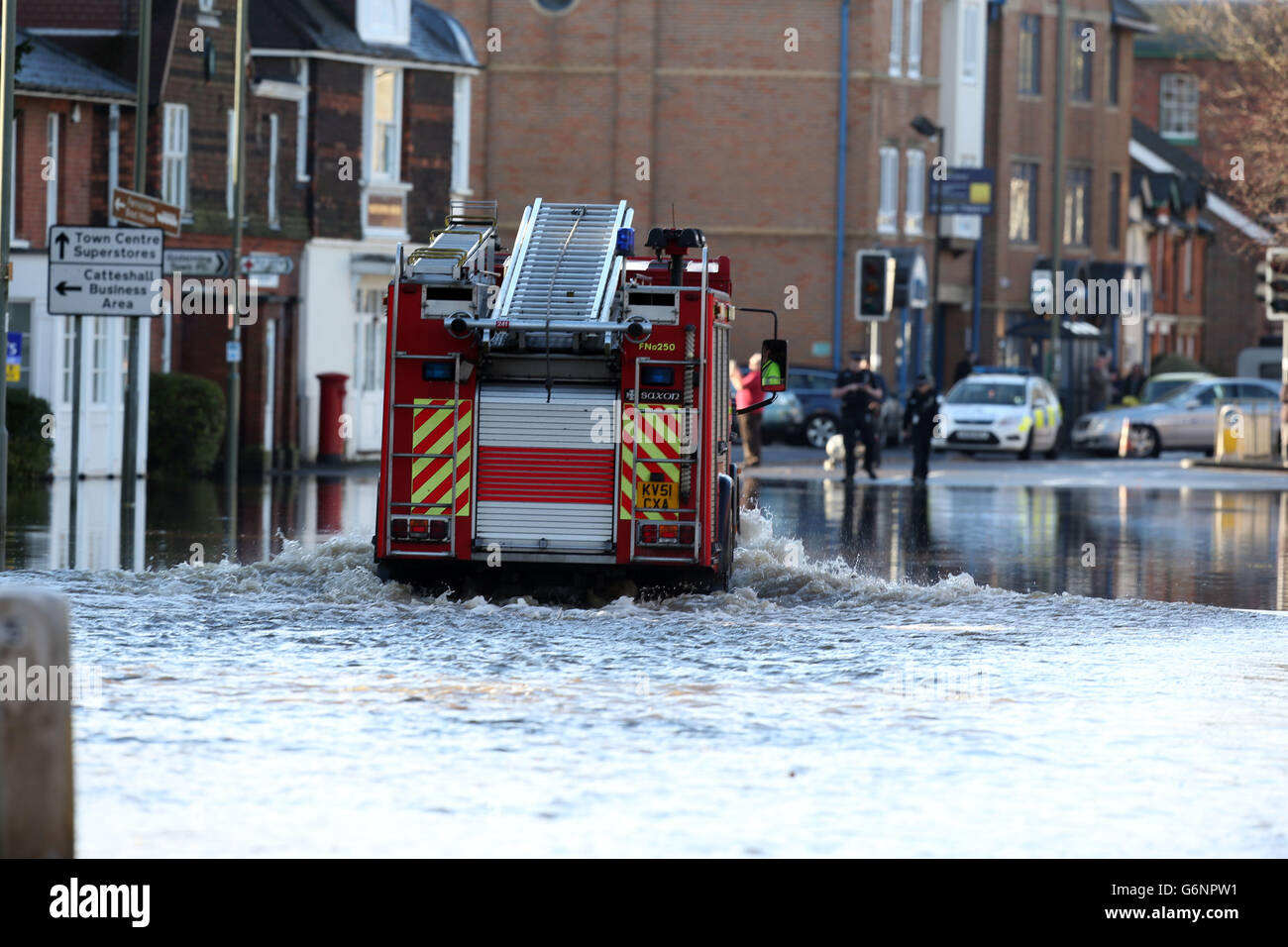 A fire engine drives through a flooded road in Godalming in Surrey ...