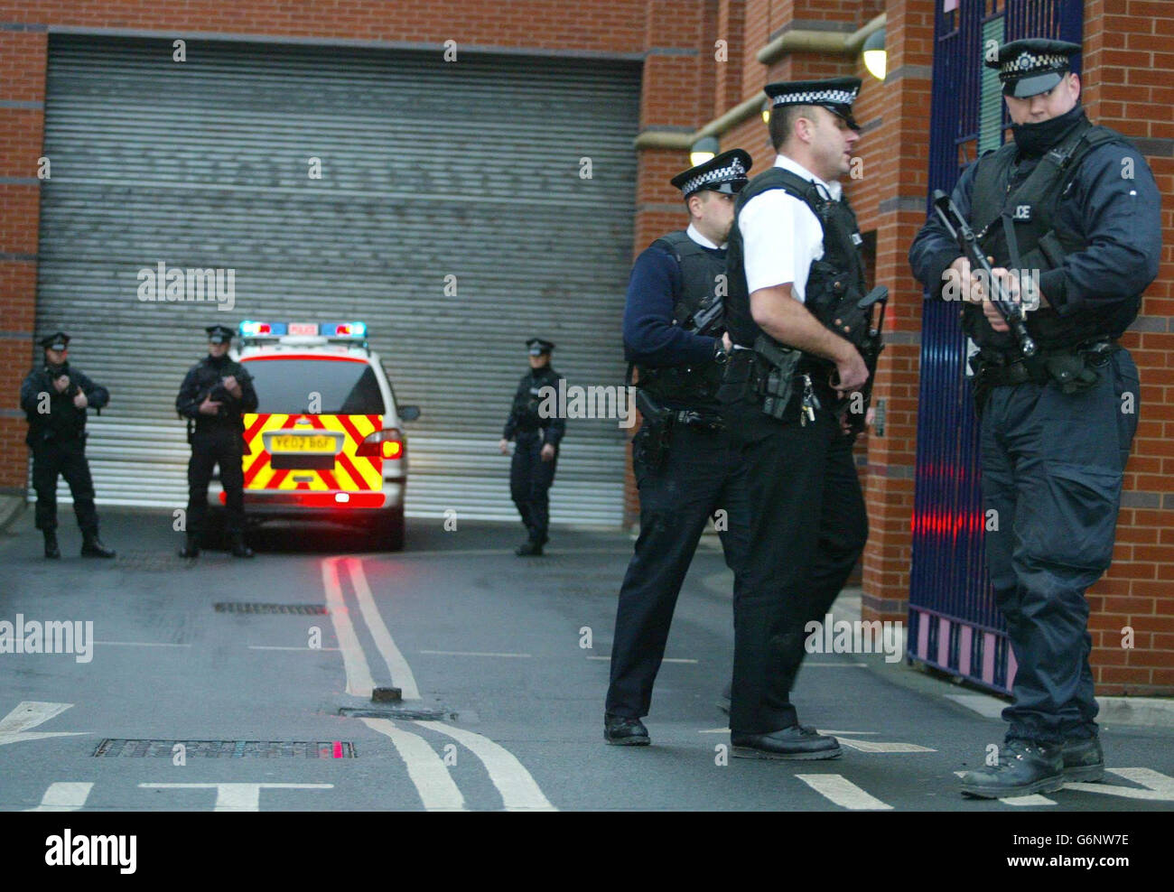 Armed police stand guard as a van (not shown) believed to be carrying ...