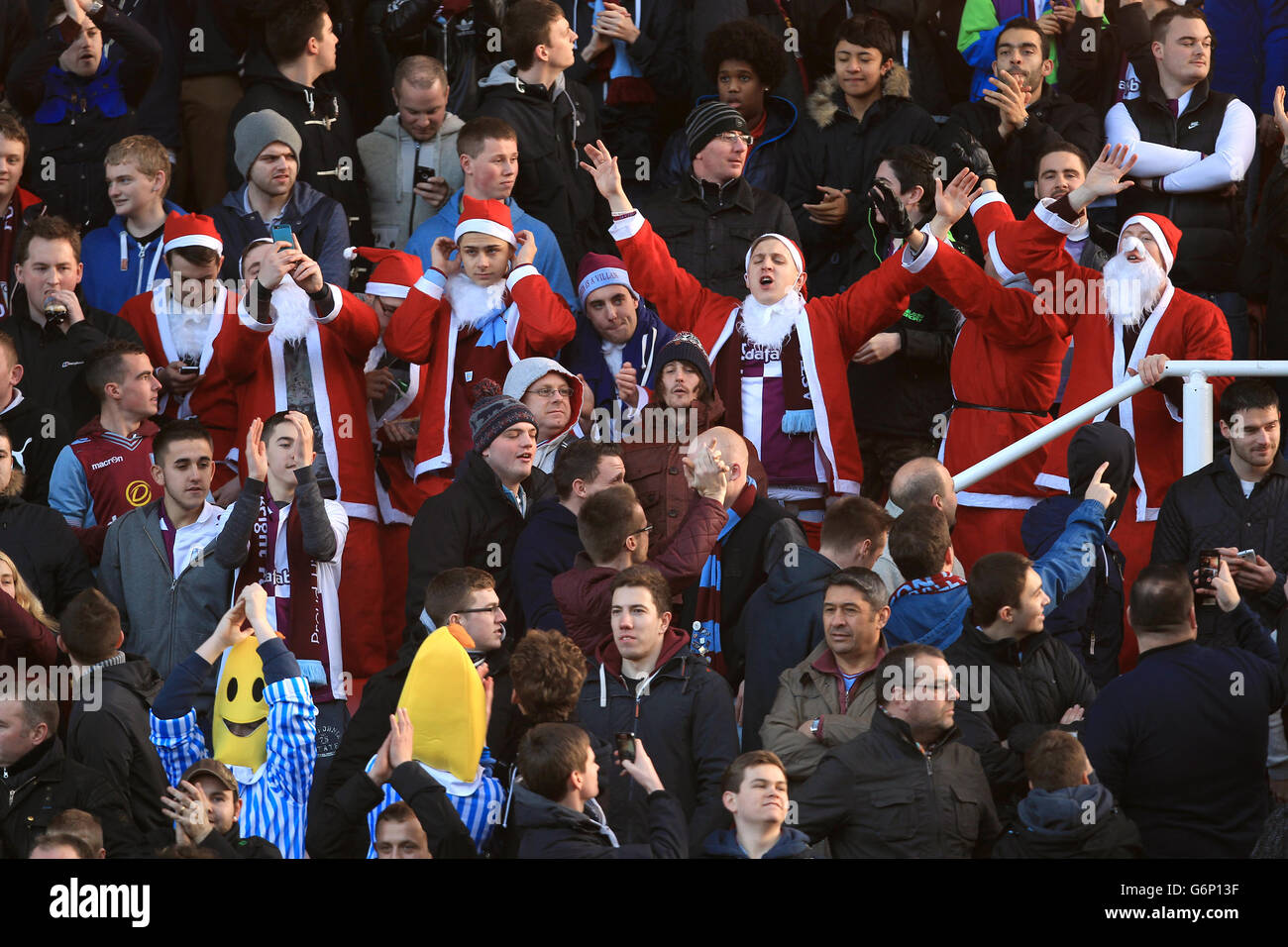 Fans dressed as Santa cheer on their side in the stands Stock Photo - Alamy