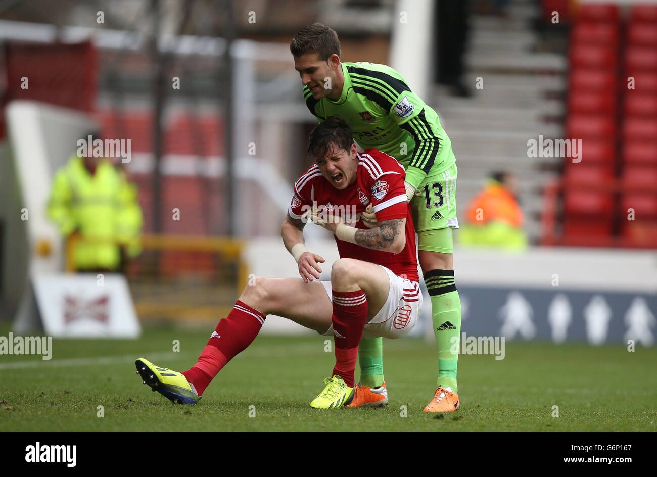 Nottingham Forest's Greg Halford is helped back up by West Ham United's ...