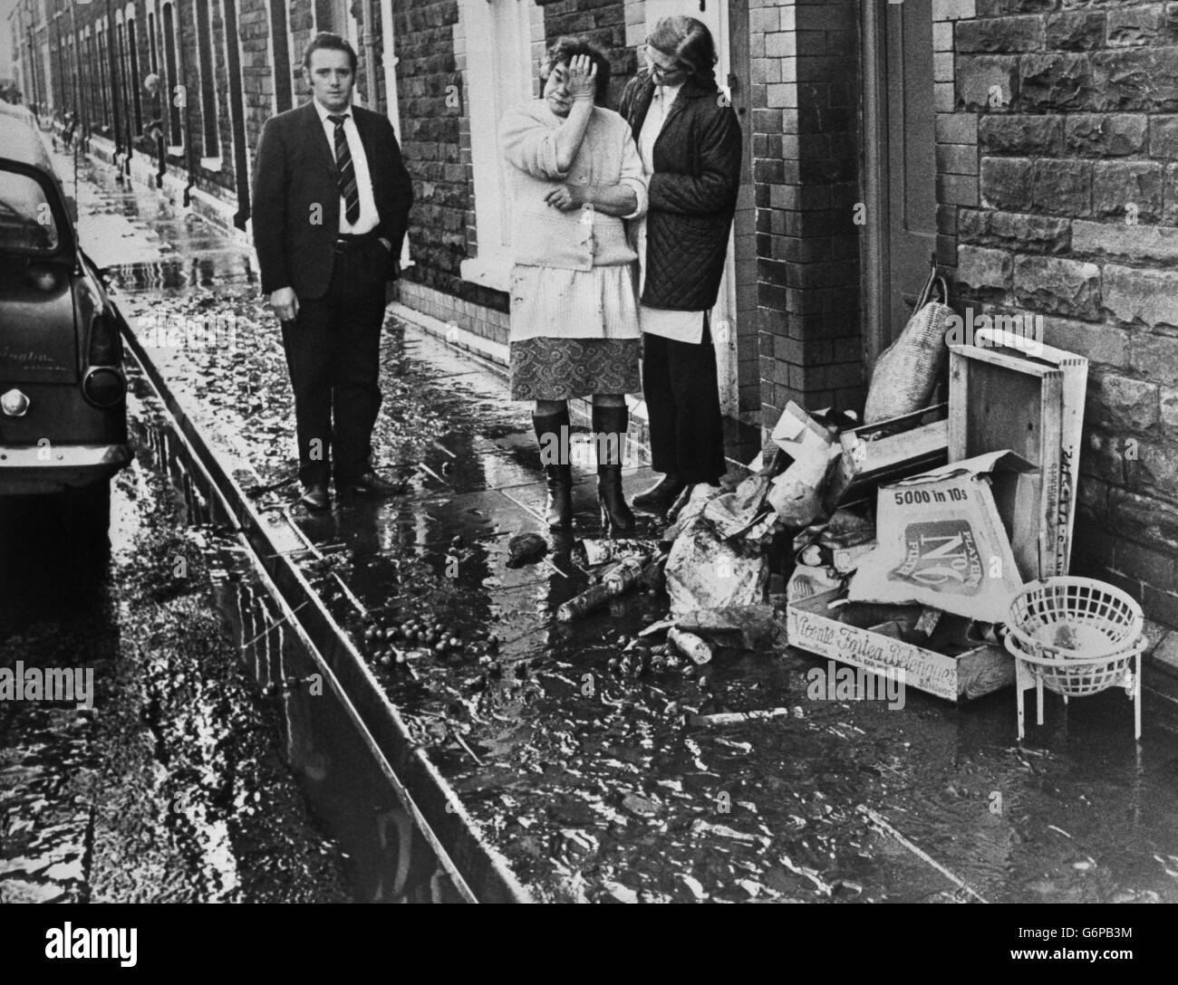 Mrs Pugh (c) was comforted by neighbours as she looked at some of the ...