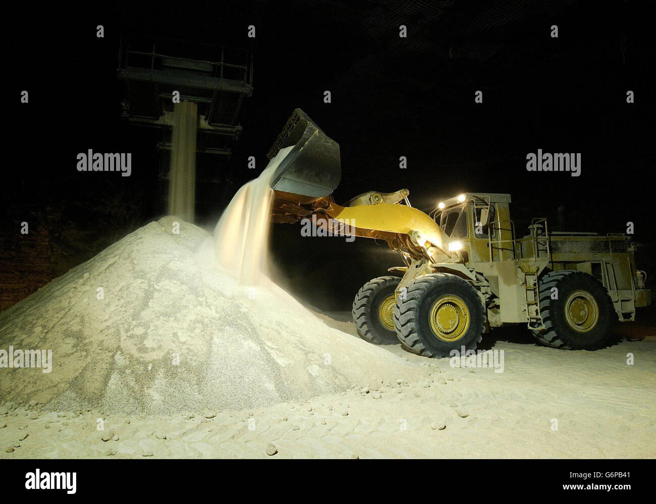 A mechanical shovel stockpiles rock salt, deep underground at Salt ...