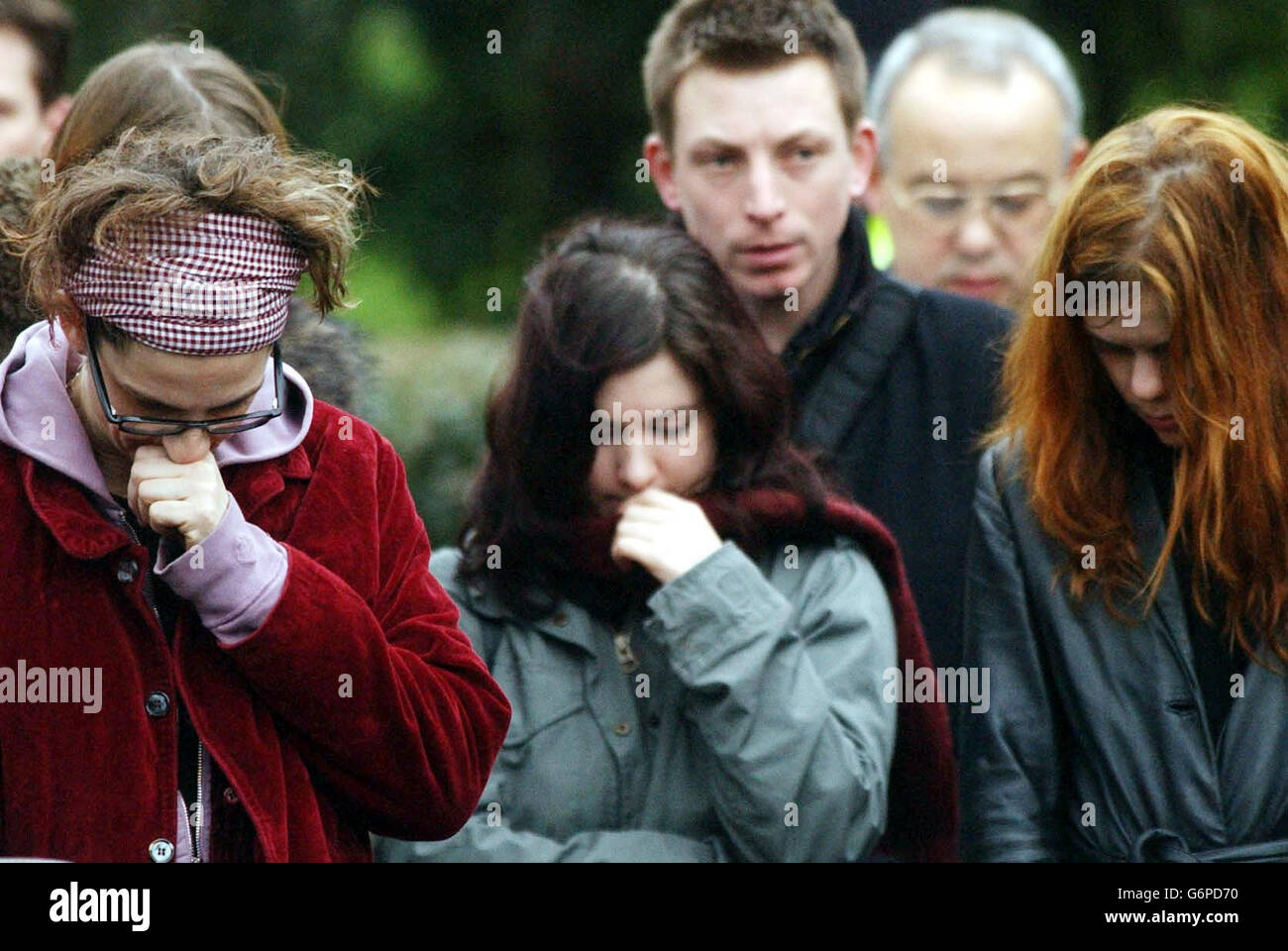 Mourners lower their heads, during the memorial service taking place ...