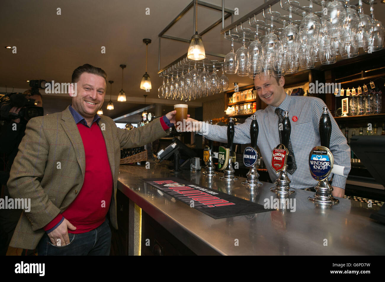 Tom from Beaconsfield (left) buys the first pint from shift manager ...