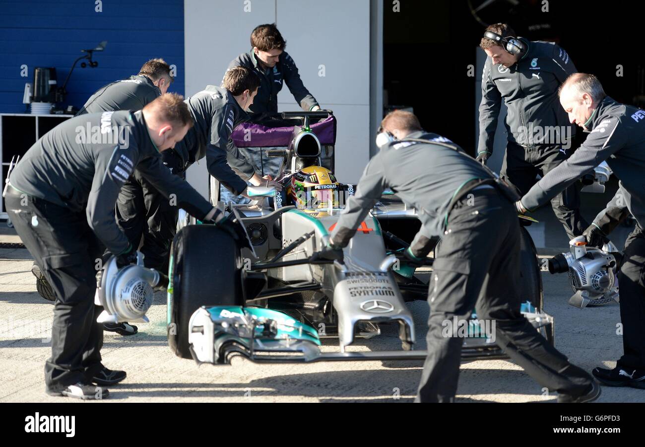 Mercedes' mechanics push driver Lewis Hamilton into the team garage ...