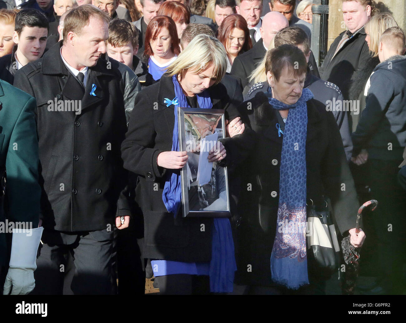 Norma McDowell (centre) partner of Simon Chase, holding a photograph of ...
