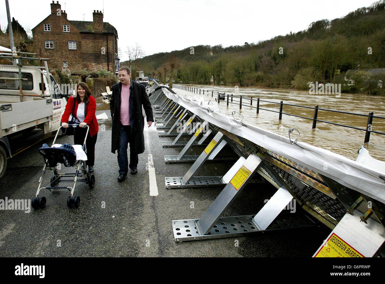 Ironbridge residents walk along the flooded Warfage Bank, protected by ...