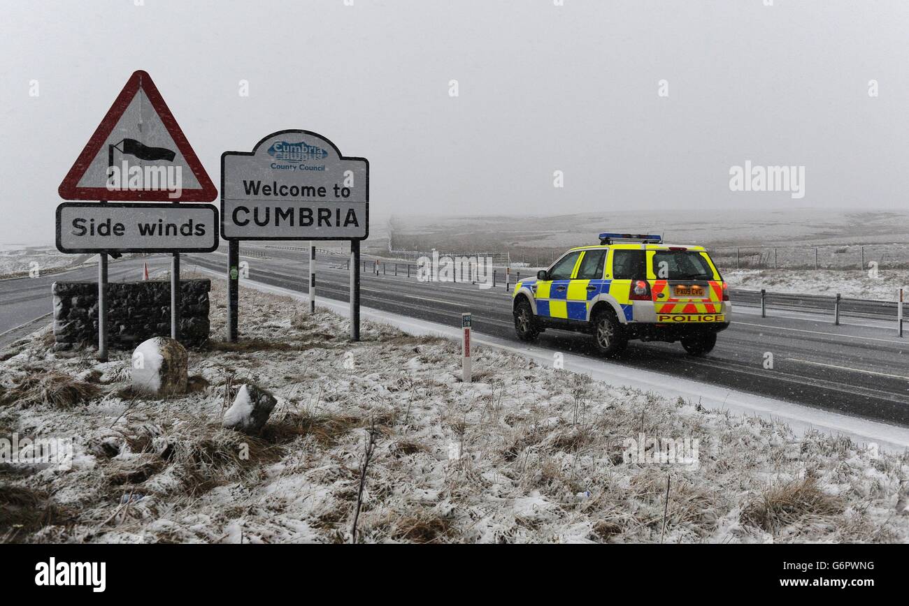 A police vehicle makes its way along the A66 as hill snow falls in the ...