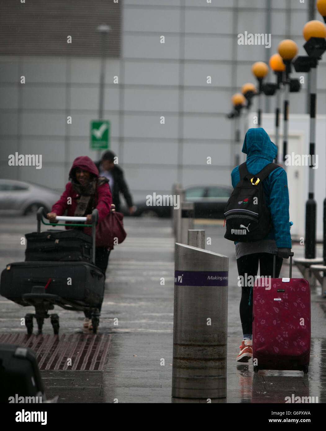 Passengers brave the rain at Terminal 3 of Heathrow Airport as the wet ...