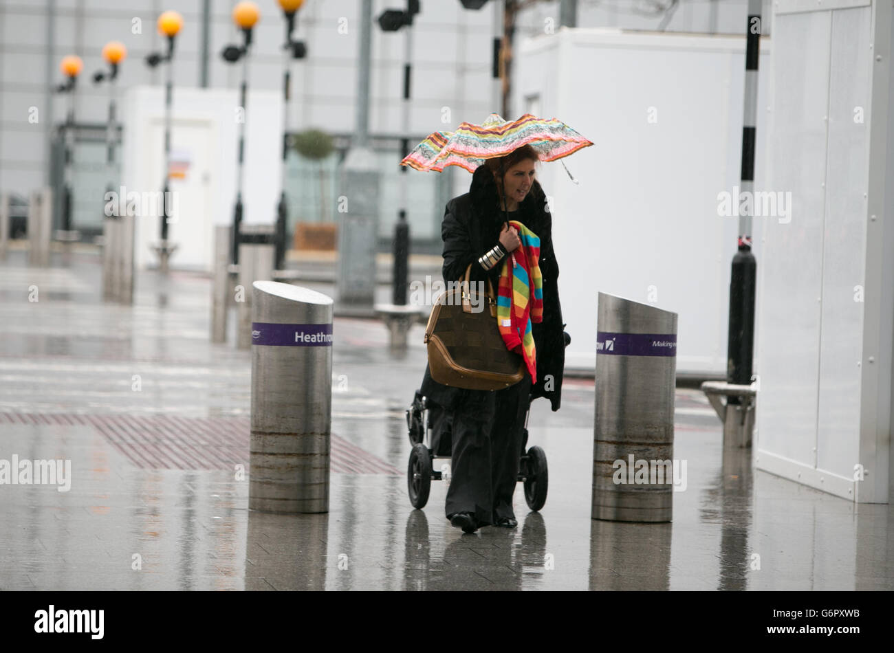 Passengers brave the rain at Terminal 3 of Heathrow Airport as the wet ...