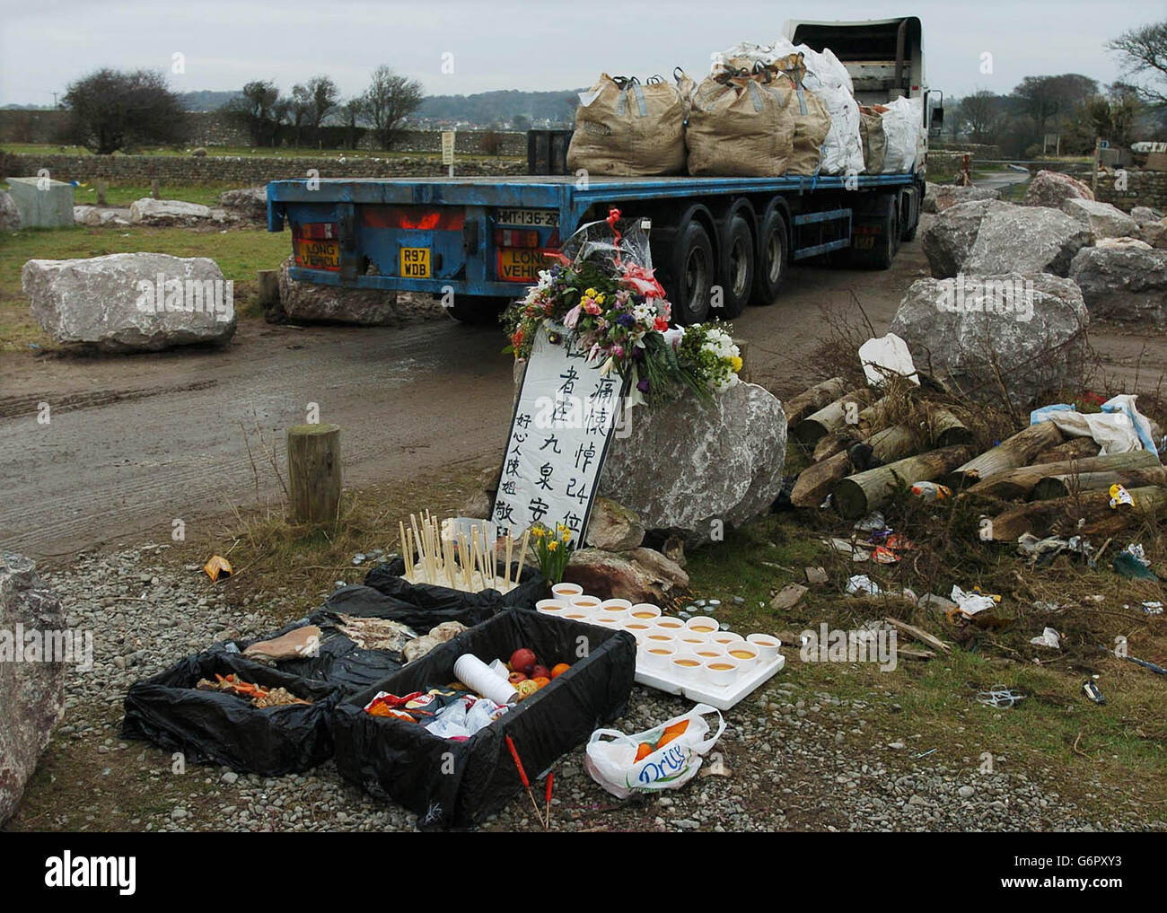 An trailer loaded with cockles drives, past a shrine constructed in ...