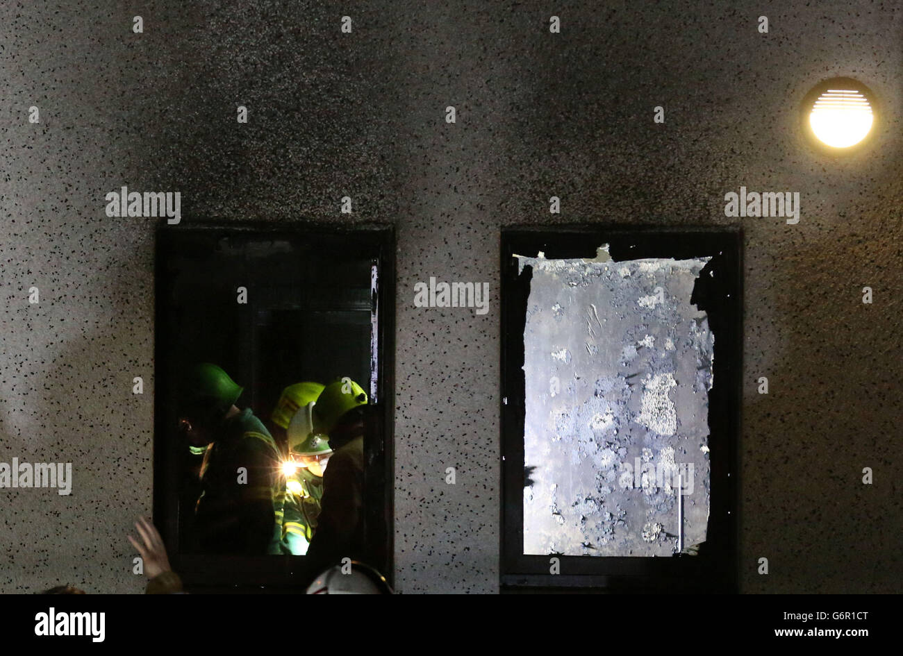 Firefighters view a burnt out flat after residents were evacuated from ...