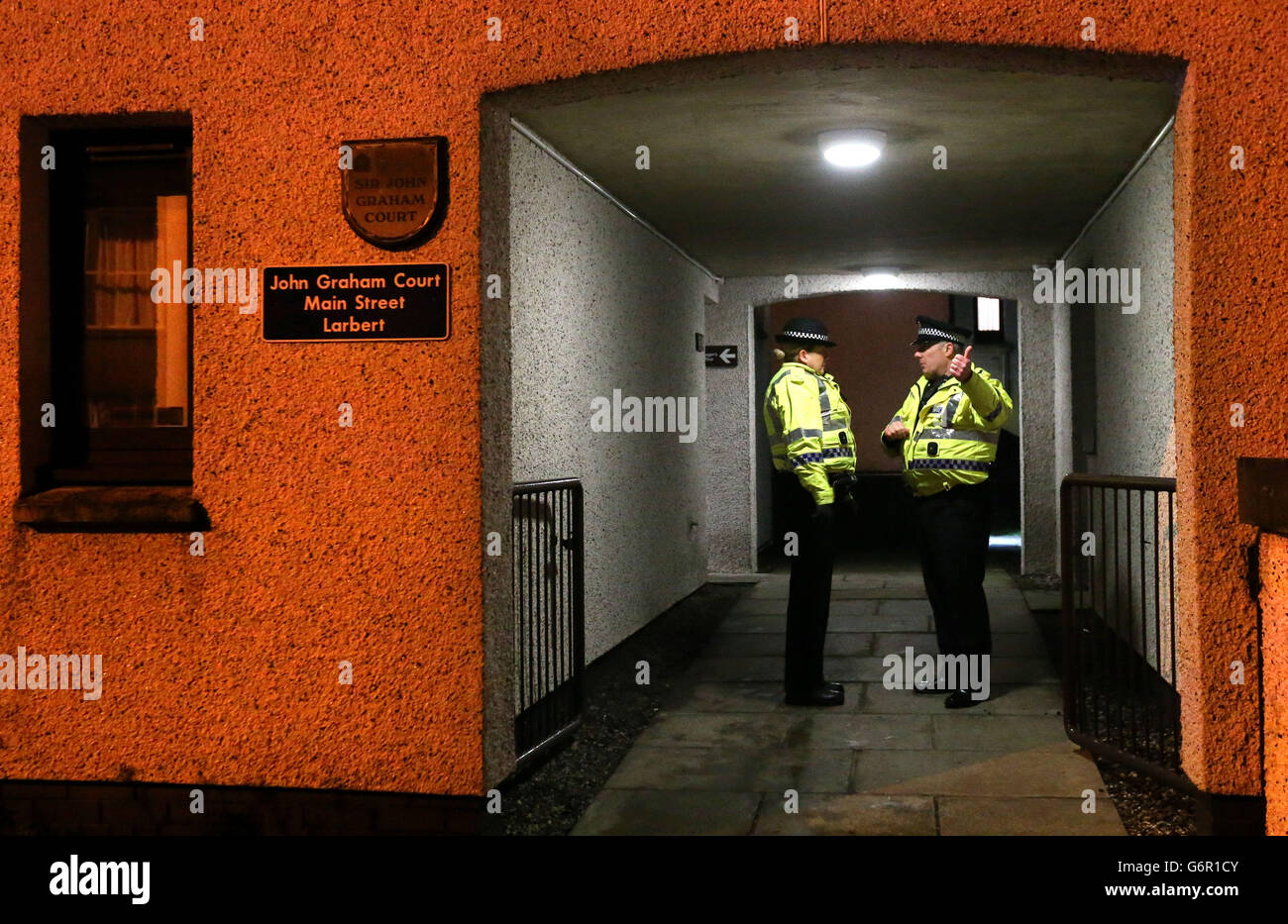 Police officers outside a burnt out flat after residents were evacuated ...