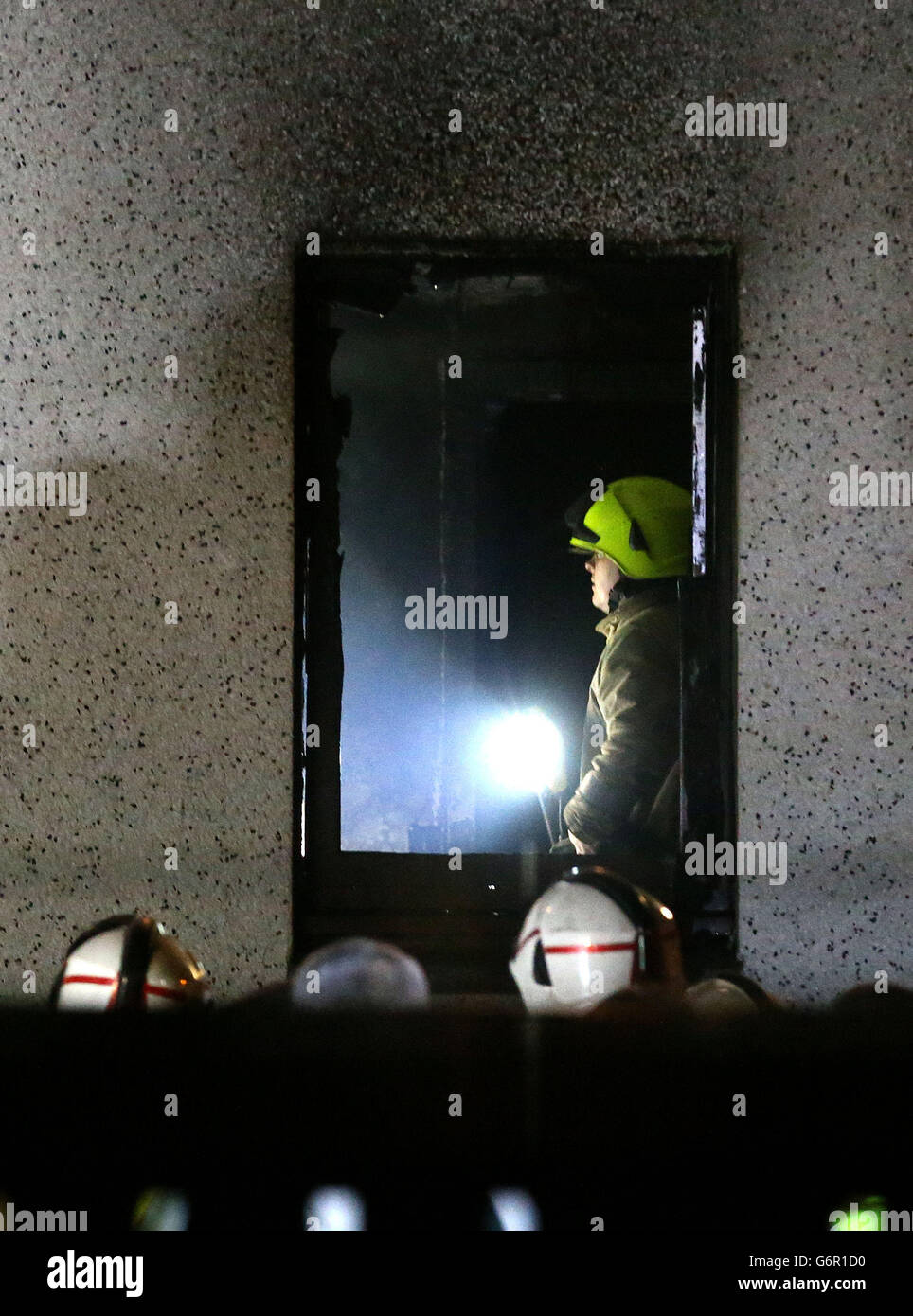 A police officer outside a burnt out flat after residents were ...