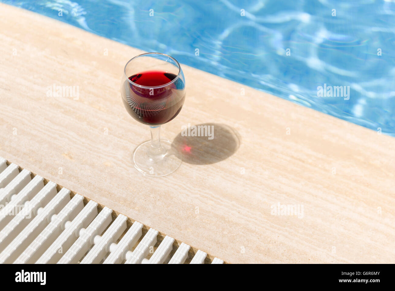 A glass of wine near the swimming pools edge Stock Photo - Alamy
