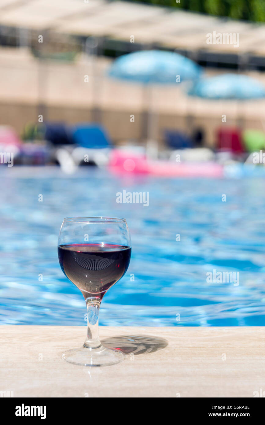 A glass of wine near the swimming pools edge Stock Photo - Alamy