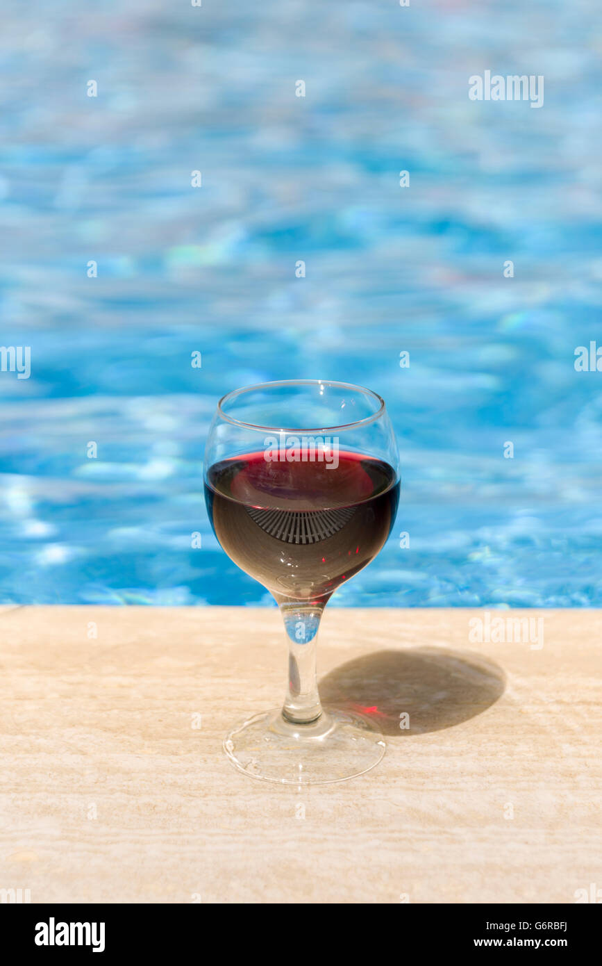 A glass of wine near the swimming pools edge Stock Photo - Alamy