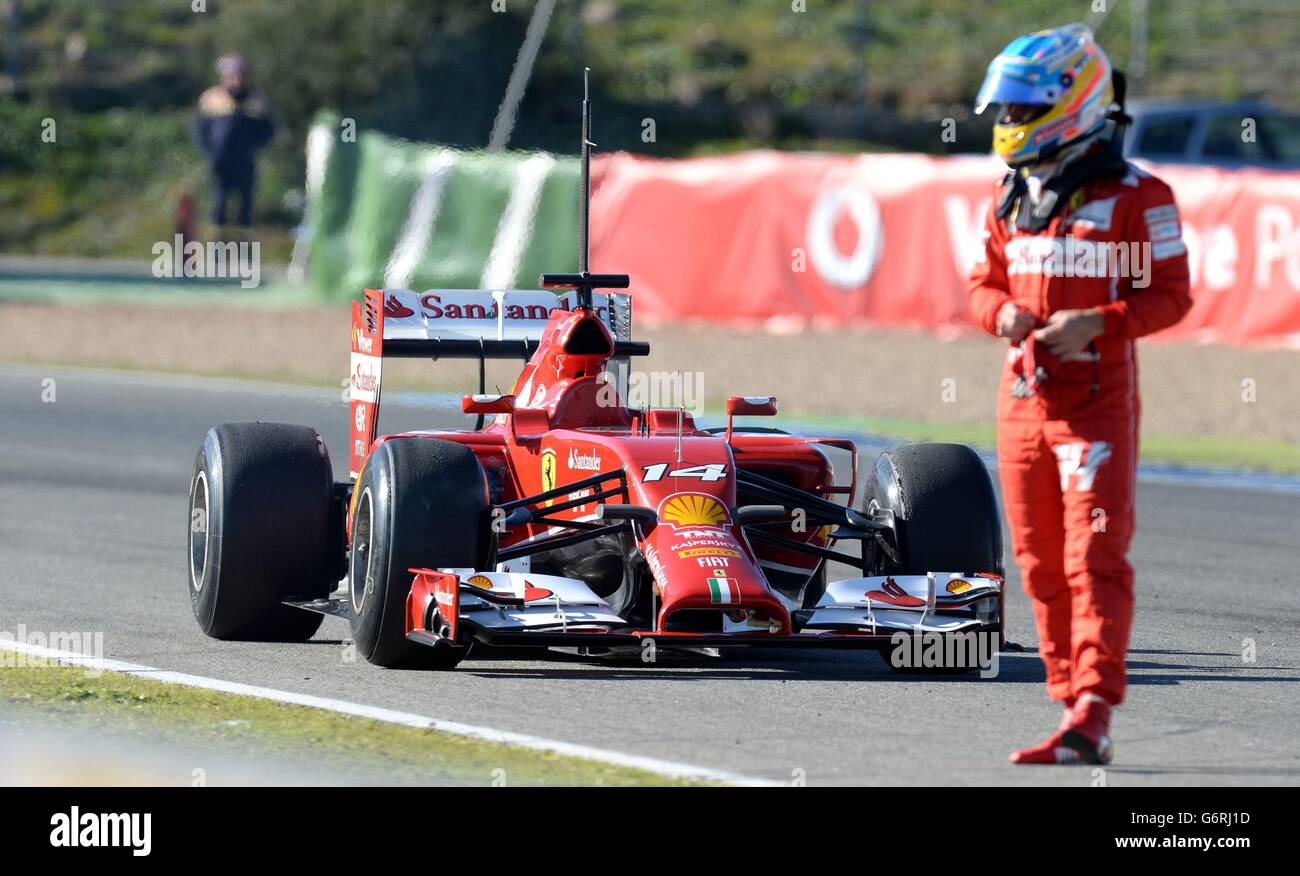 Ferrari driver Fernando Alonso stands next to his car after it stopped ...