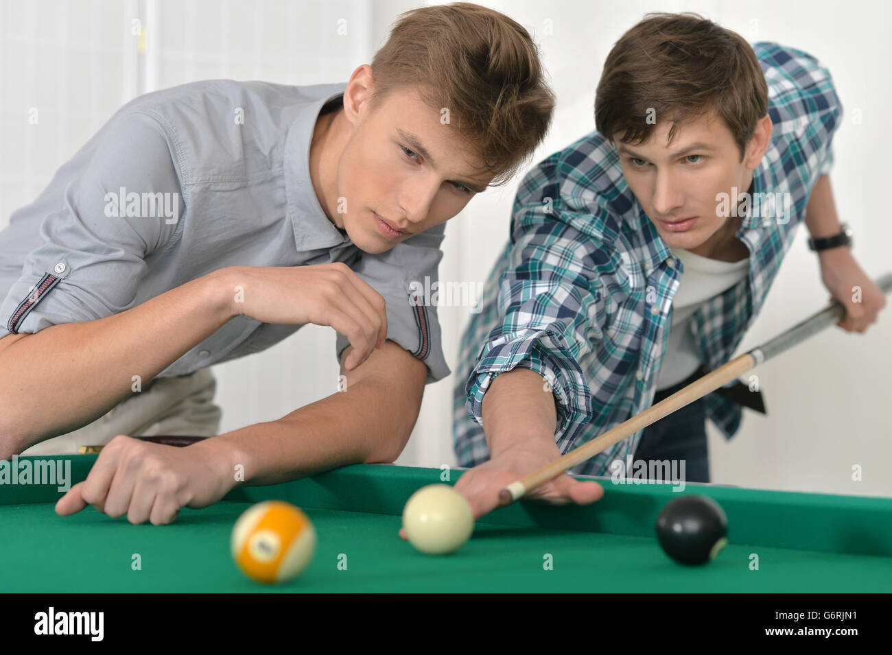 Young men playing billiards Stock Photo - Alamy