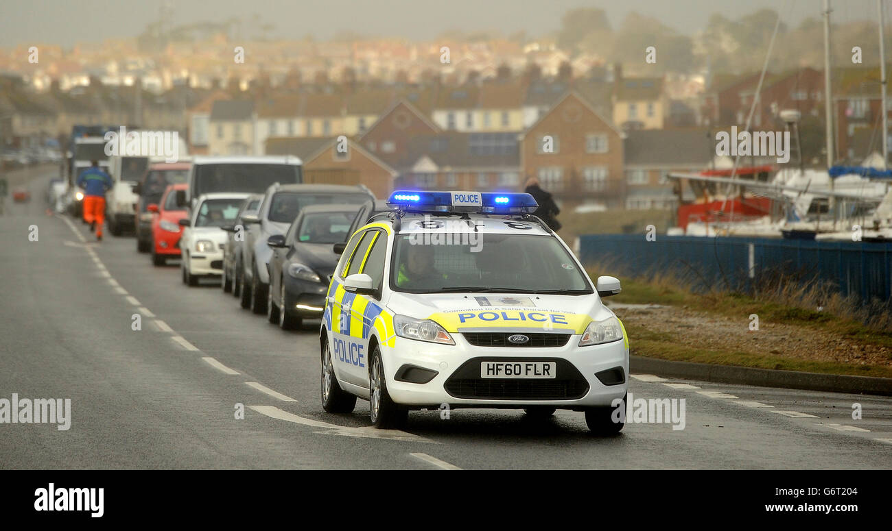 A police officer uses his vehicle to block the flooded Portland Beach ...